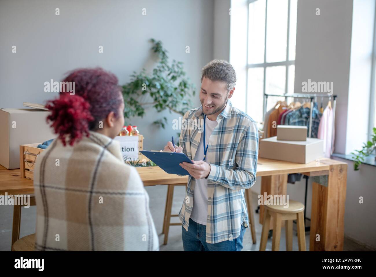 Young laughing man writing note while talking to girl Stock Photo - Alamy