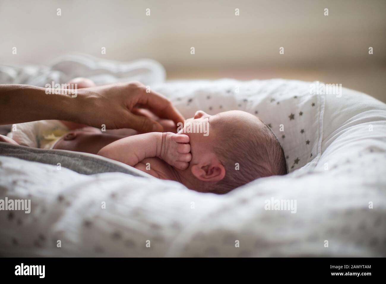 Mother touching cute newborn baby son in bassinet Stock Photo - Alamy