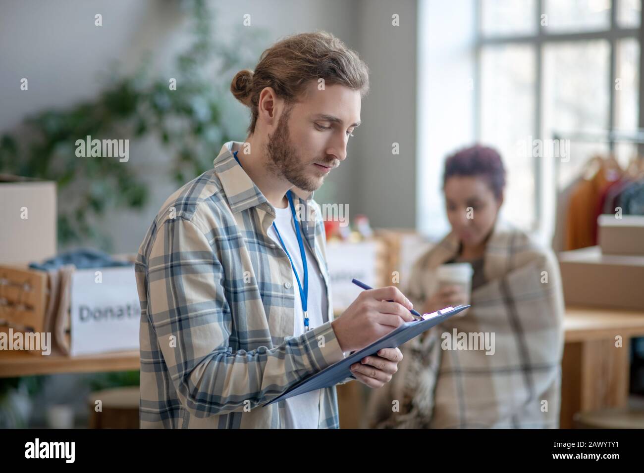 Young busy man standing indoors at work and writing Stock Photo - Alamy