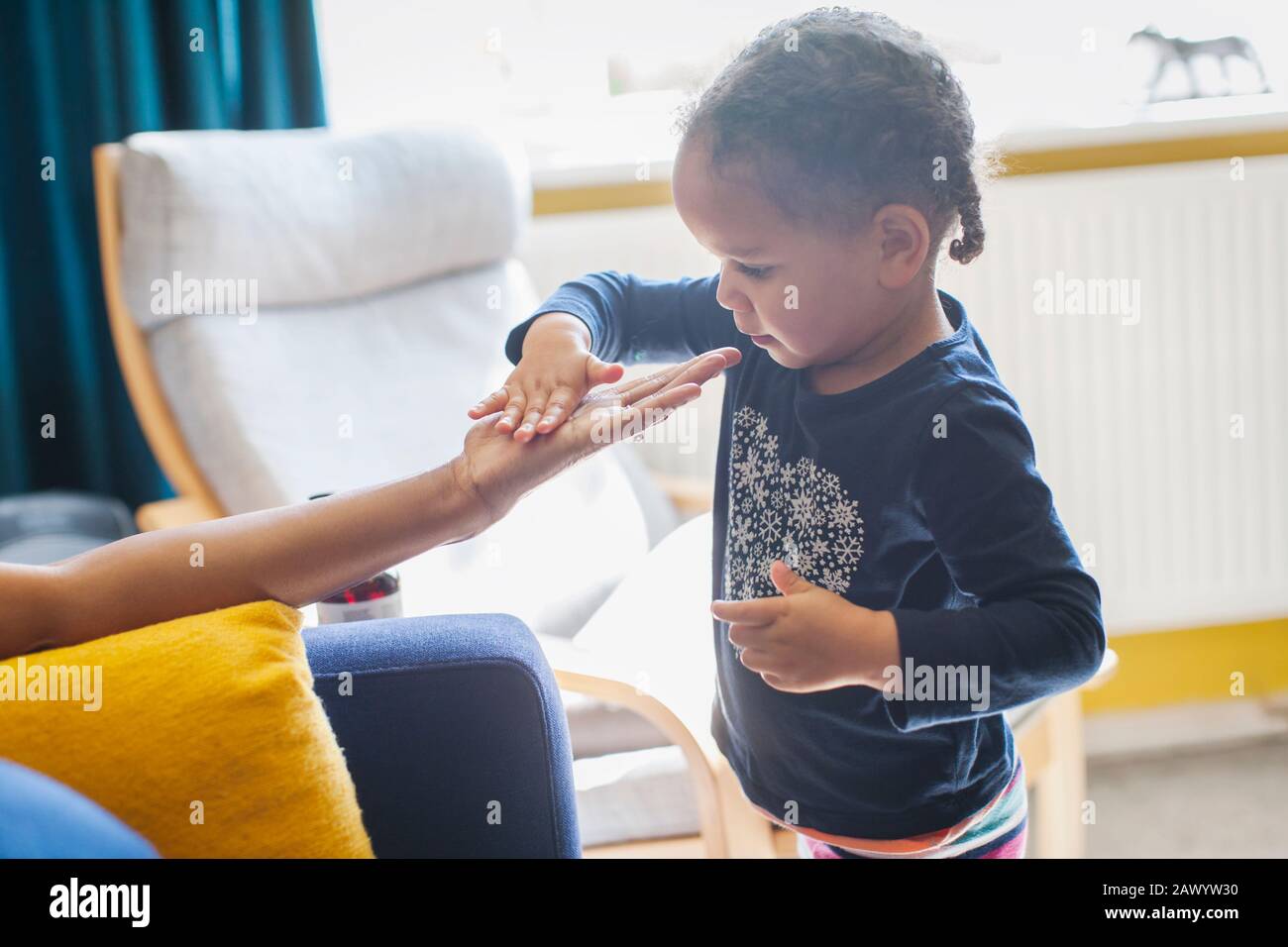 Curious girl touching hand of mother Stock Photo - Alamy