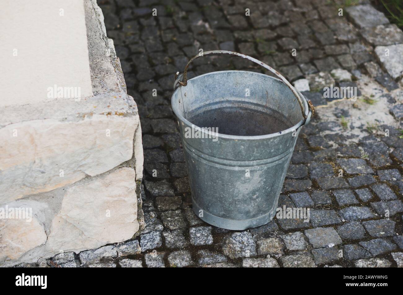 Metal bucket on the ground in front of a building in the street Stock ...
