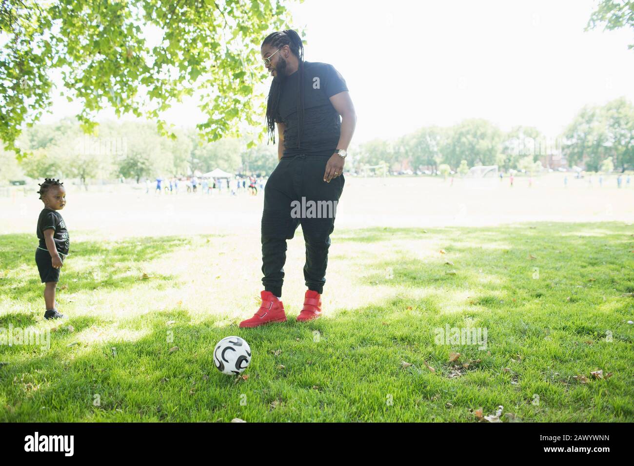 Father and toddler son playing soccer in park Stock Photo - Alamy