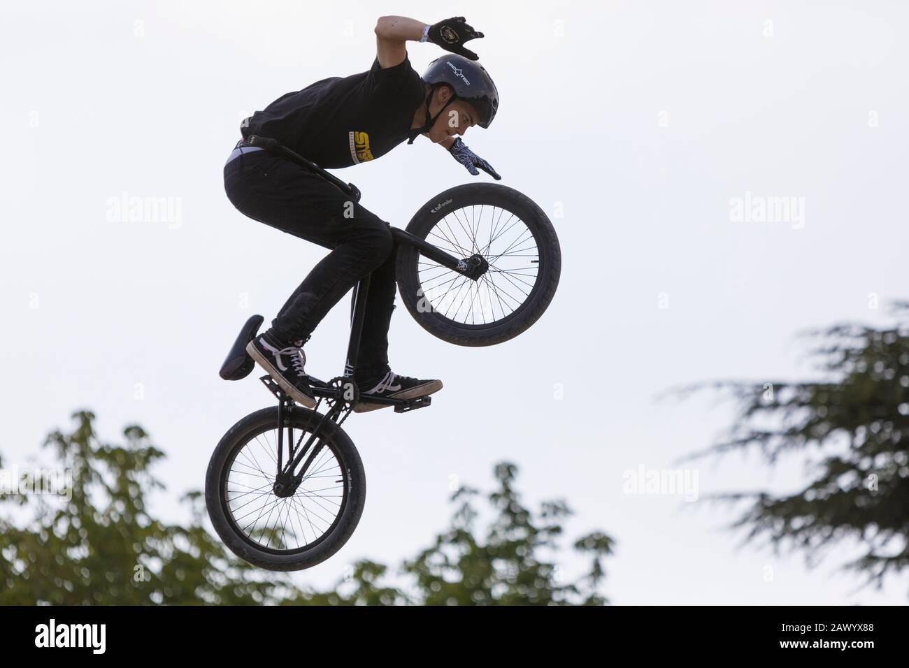 BMX rider jumping high in the air with hands off the handlebars during ...