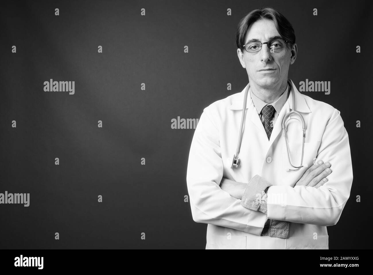 Mature handsome Italian man doctor against gray background Stock Photo ...