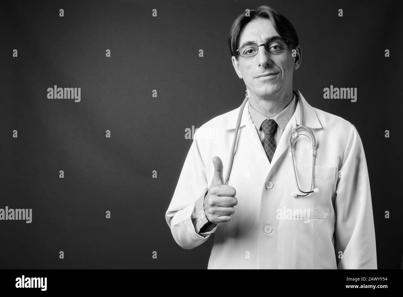 Mature handsome Italian man doctor against gray background Stock Photo ...