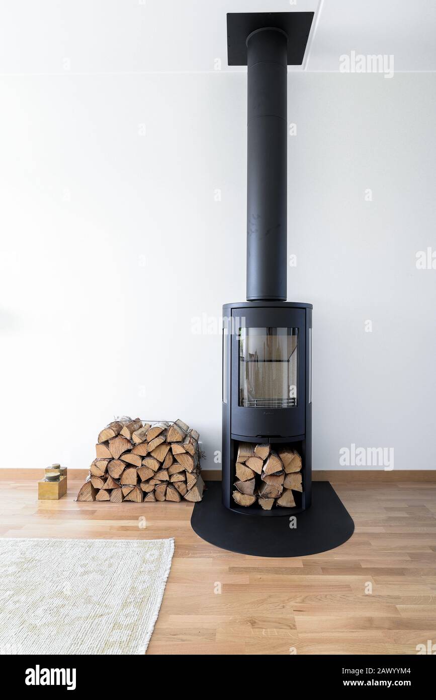 Vertical shot of a modern chimney with firewoods in the room with a ...