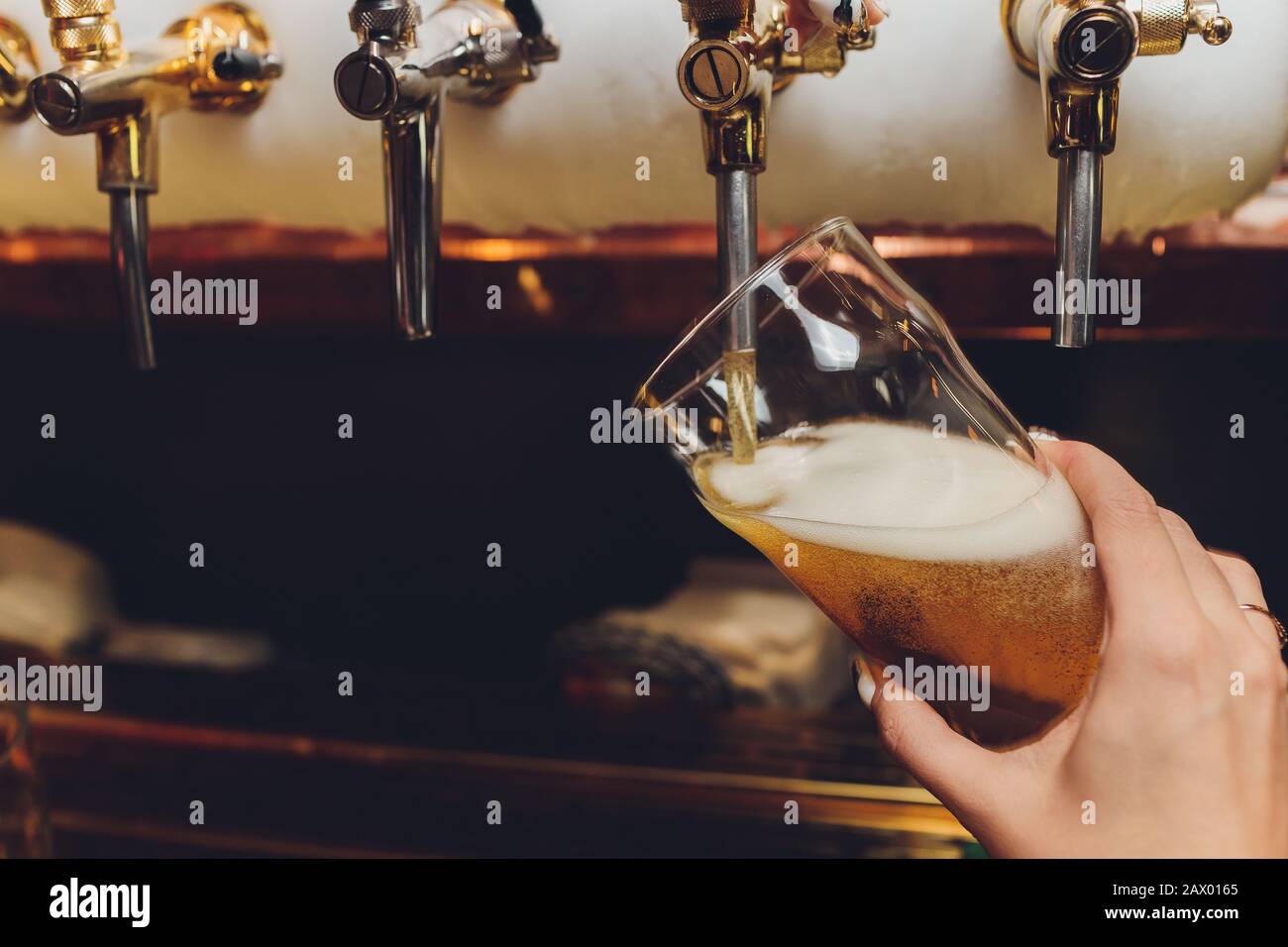 Barkeeper pulling a pint of beer behind the bar Stock Photo - Alamy