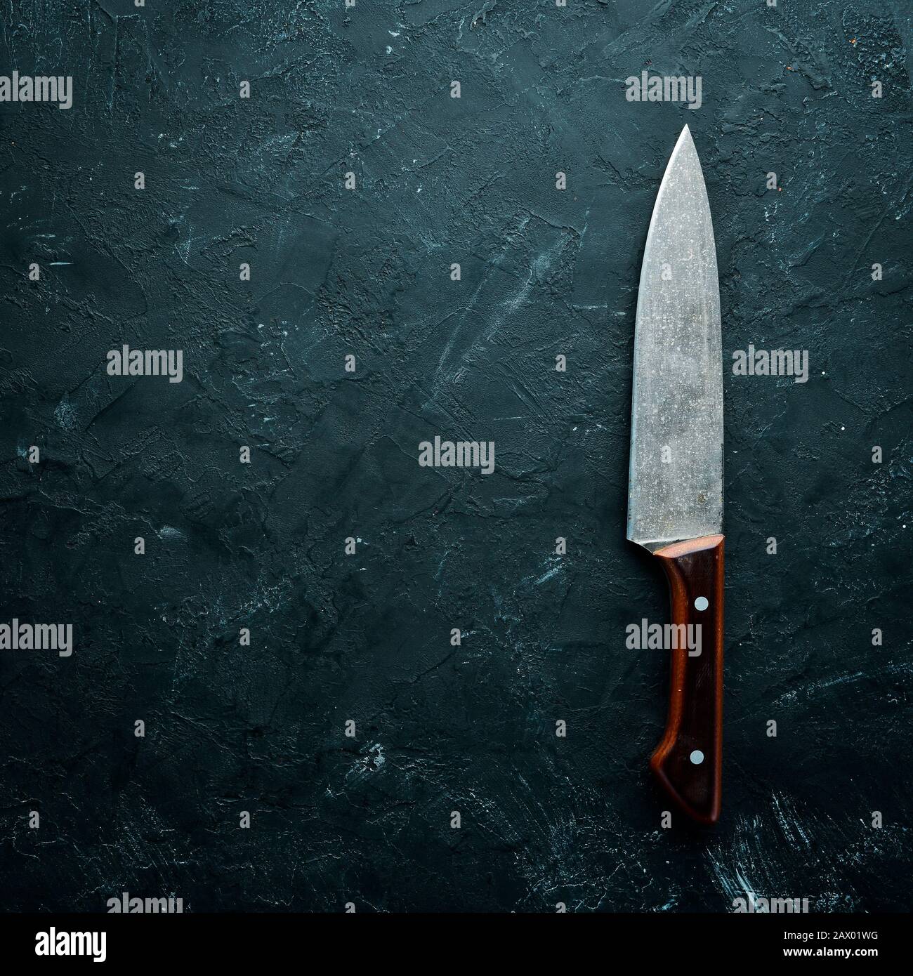 Kitchen old knife on a black stone table. Top view. Free space for your ...