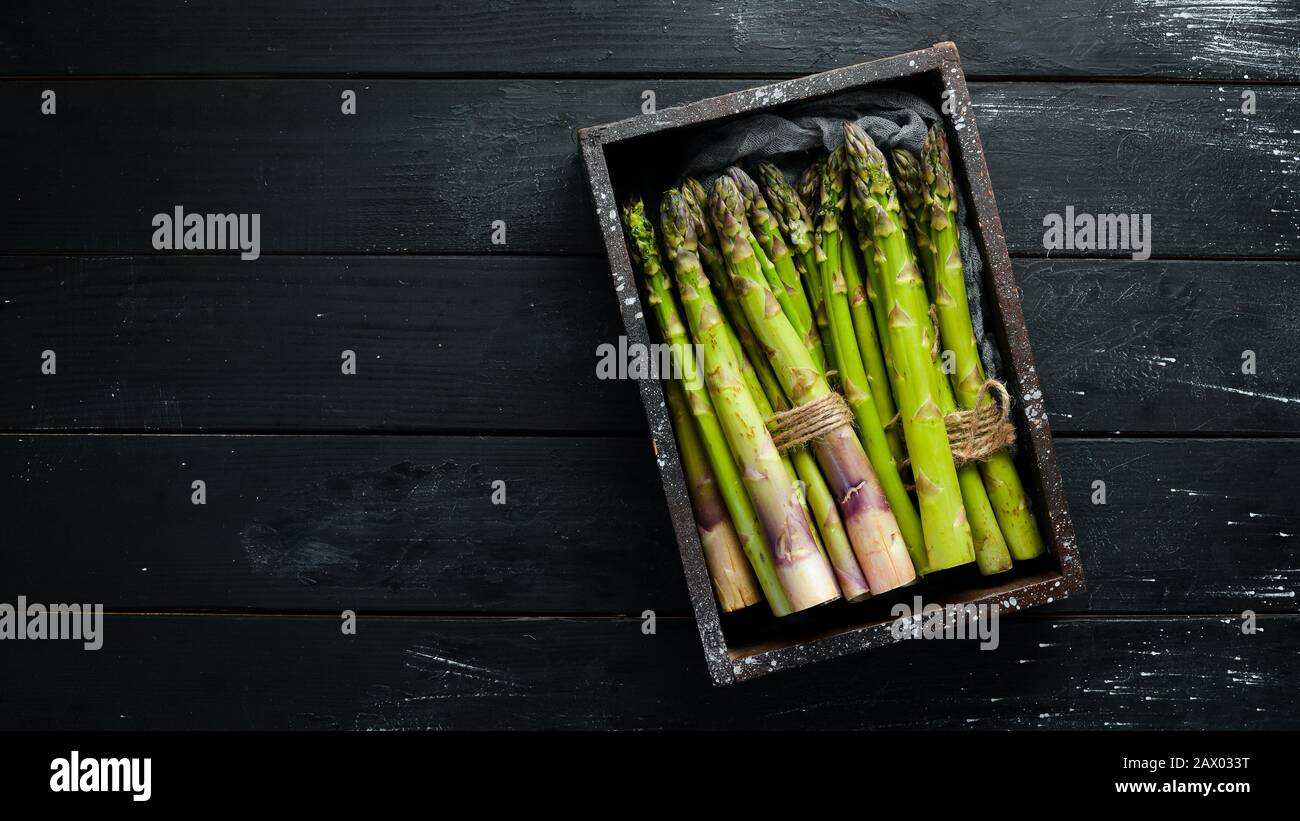 Fresh asparagus in a wooden box. Healthy food. Top view. Free space for ...