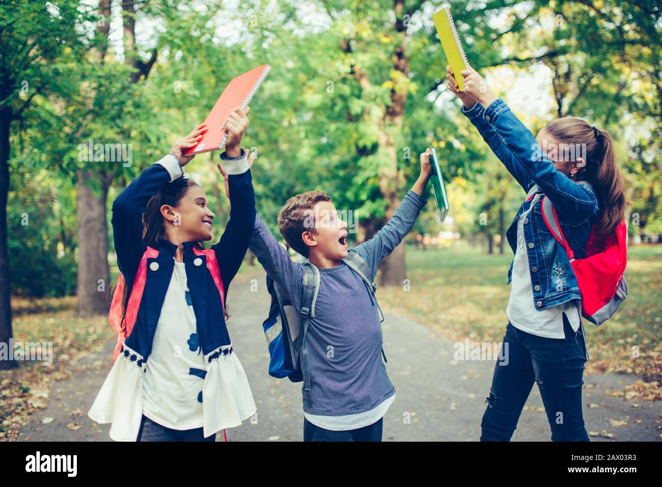 Back to school. Close up three happy friends with backpacks laughing ...