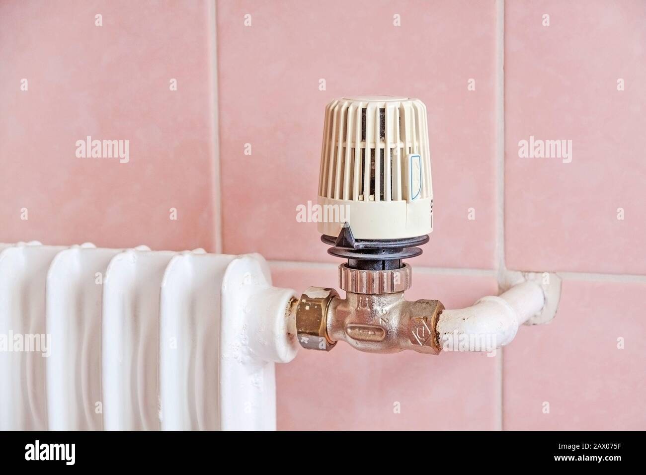 radiator with thermostat - pink tiles in background Stock Photo - Alamy