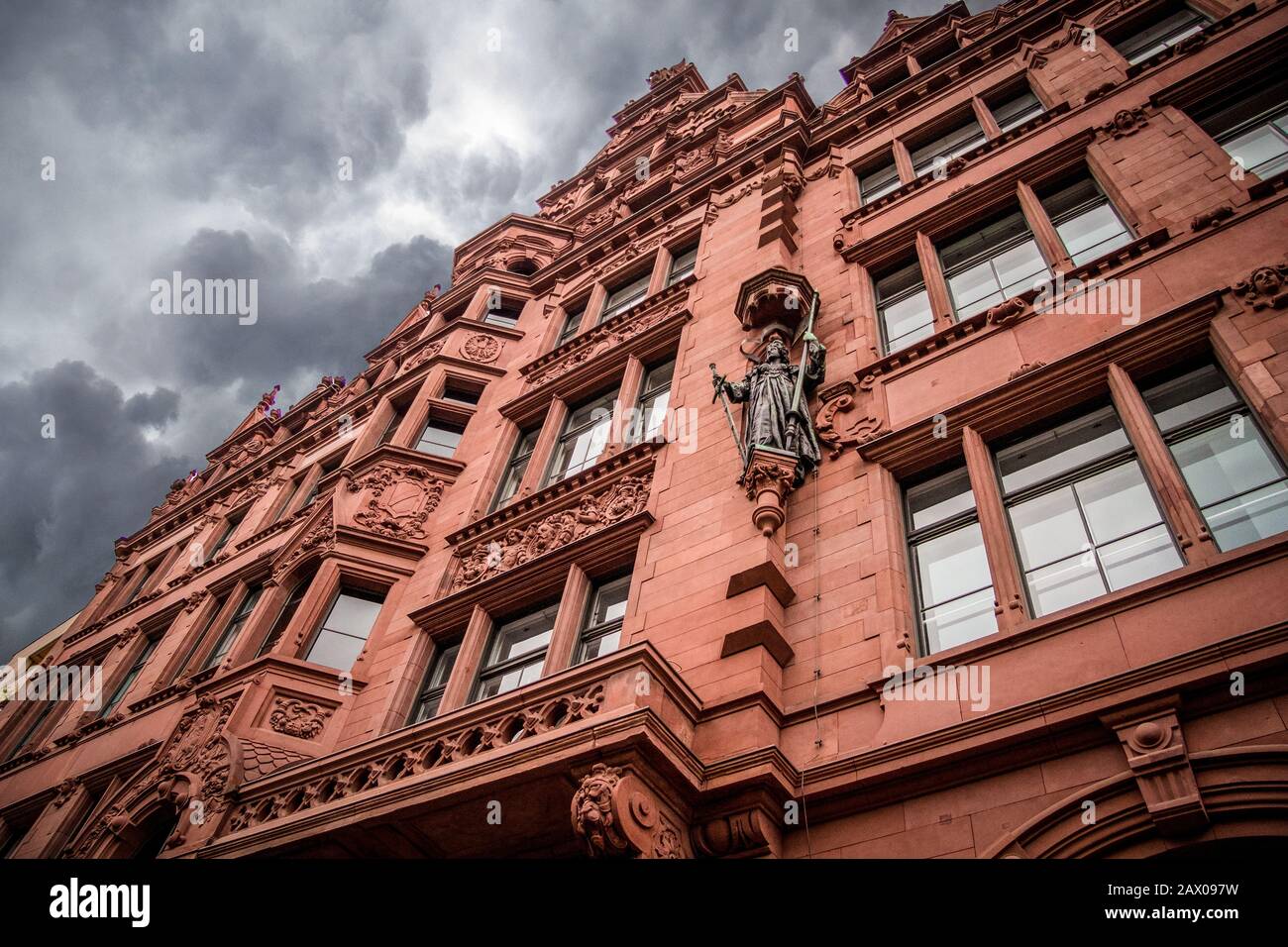 Low angle shot of a large brown building under a cloudy sky Stock Photo ...