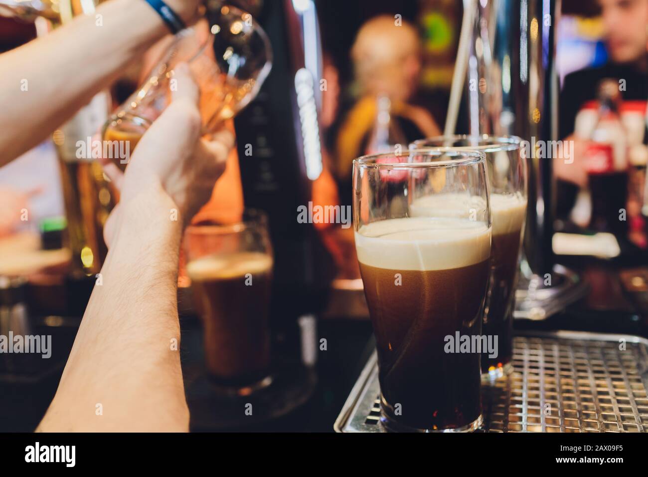 Barkeeper pulling a pint of beer behind the bar Stock Photo - Alamy