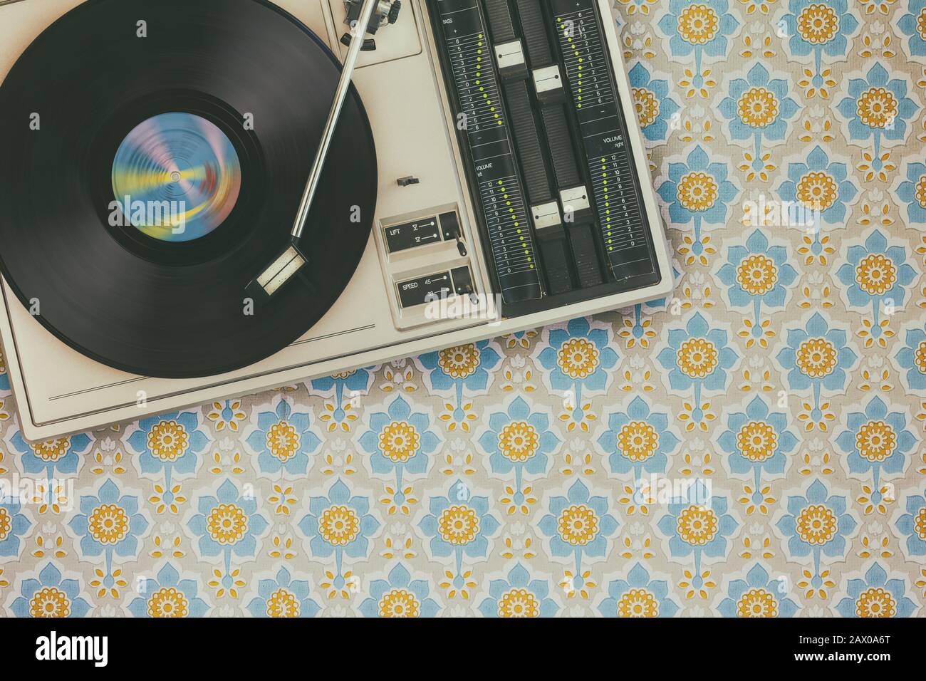 Retro styled image of an old record player on top of flower wallpaper ...