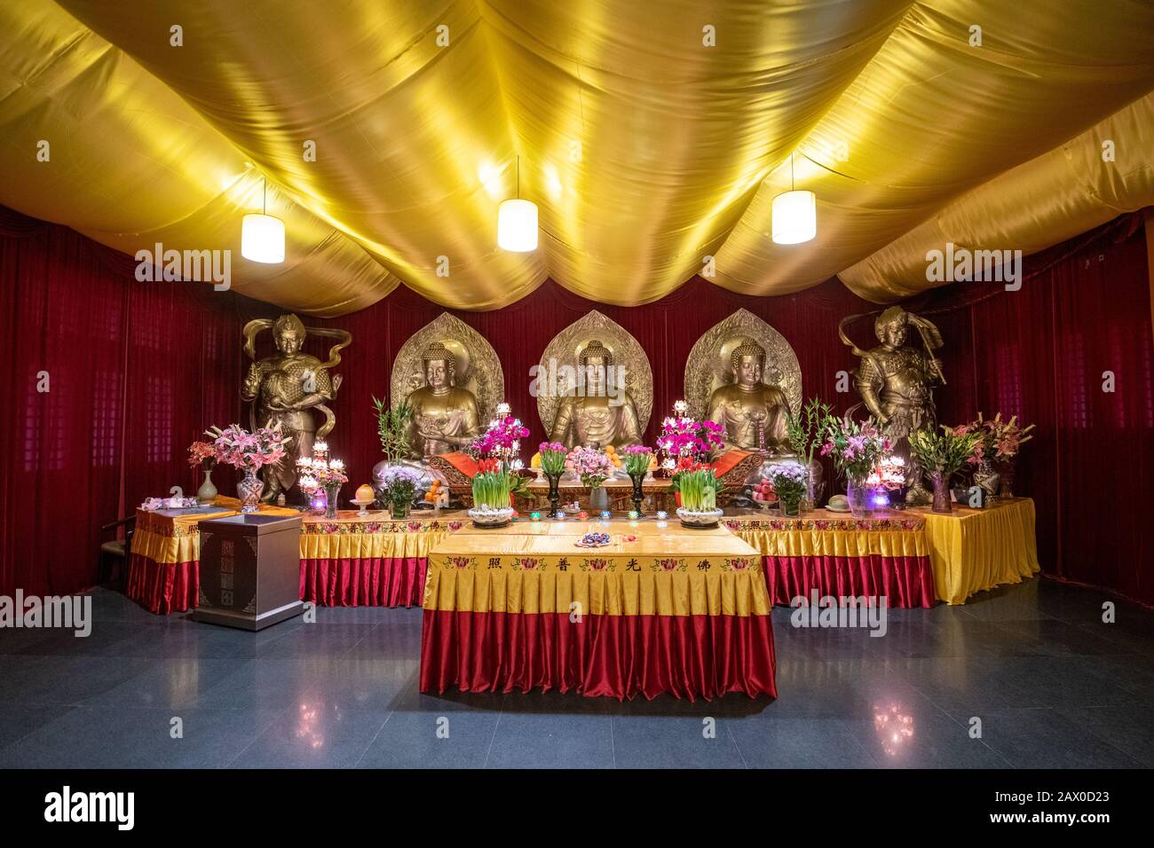 An altar in Jing'an Temple with multiple statues resting atop it ...