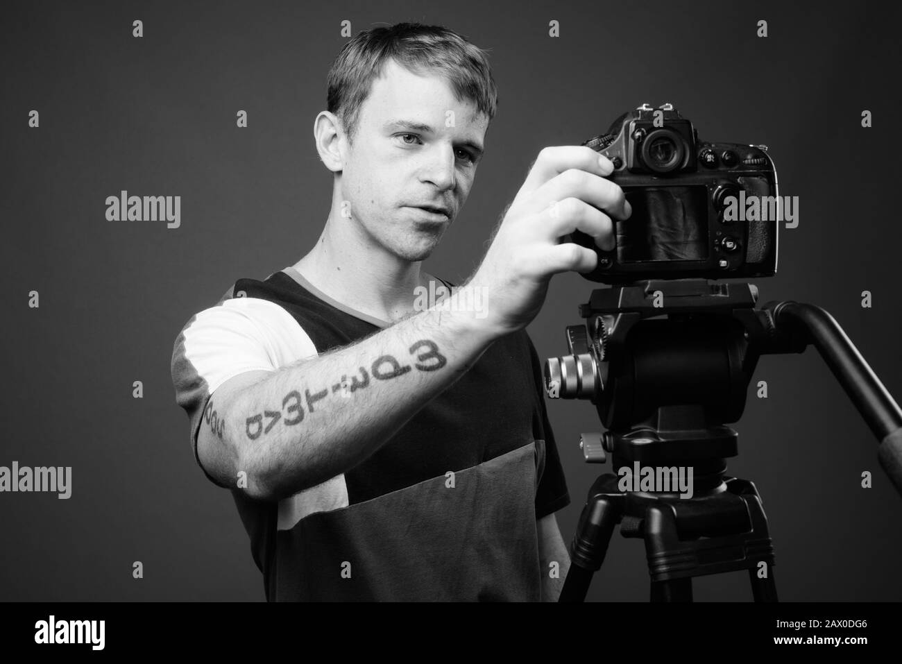 Portrait of man vlogging with camera against gray background Stock ...