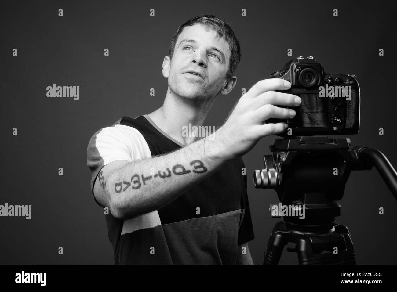 Portrait of man vlogging with camera against gray background Stock ...