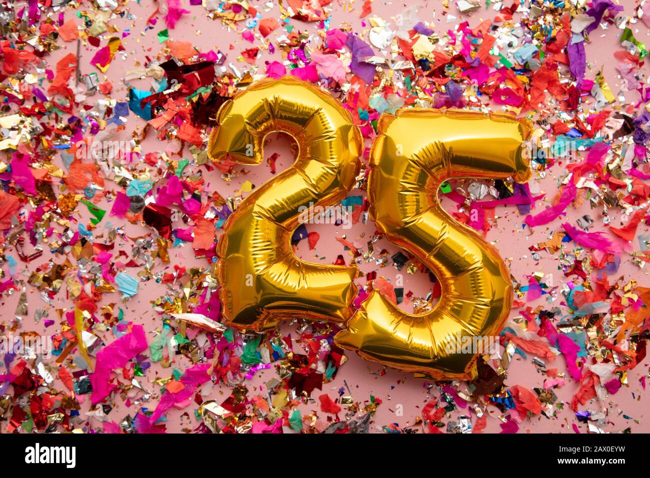 Number 25 gold birthday celebration balloon on a confetti glitter ...