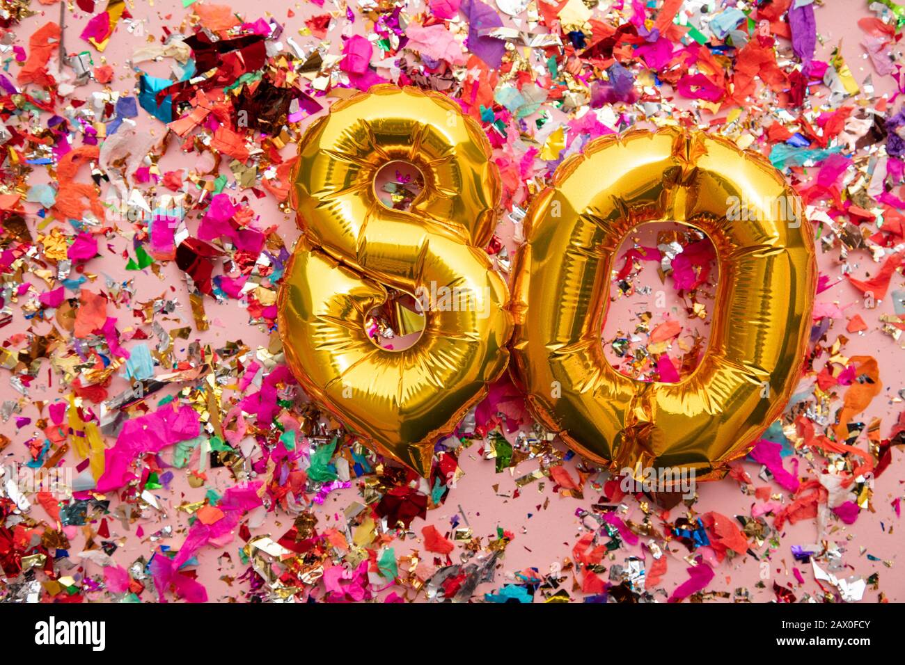 Number 80 gold birthday celebration balloon on a confetti glitter ...