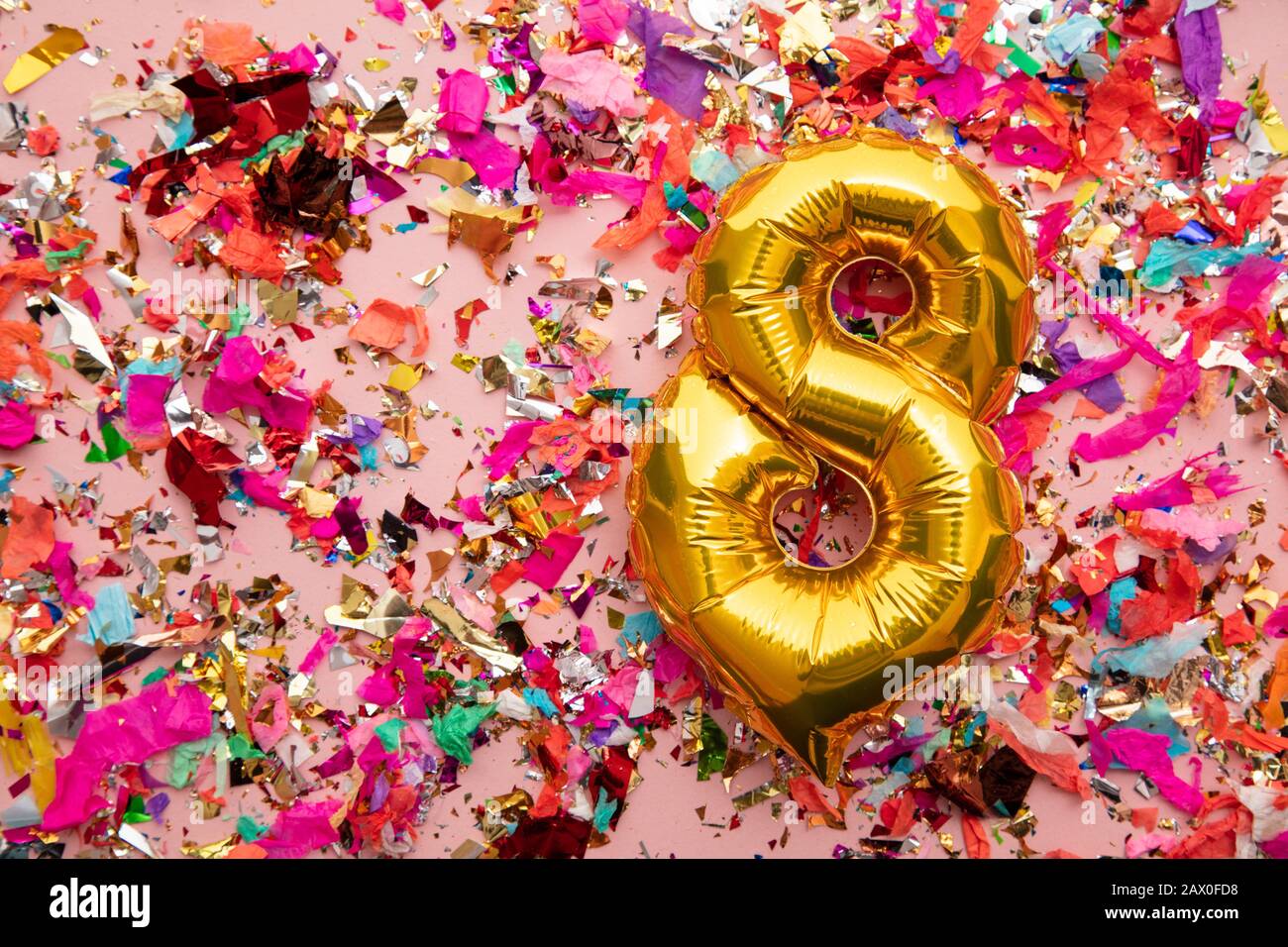 Number 8 gold birthday celebration balloon on a confetti glitter ...
