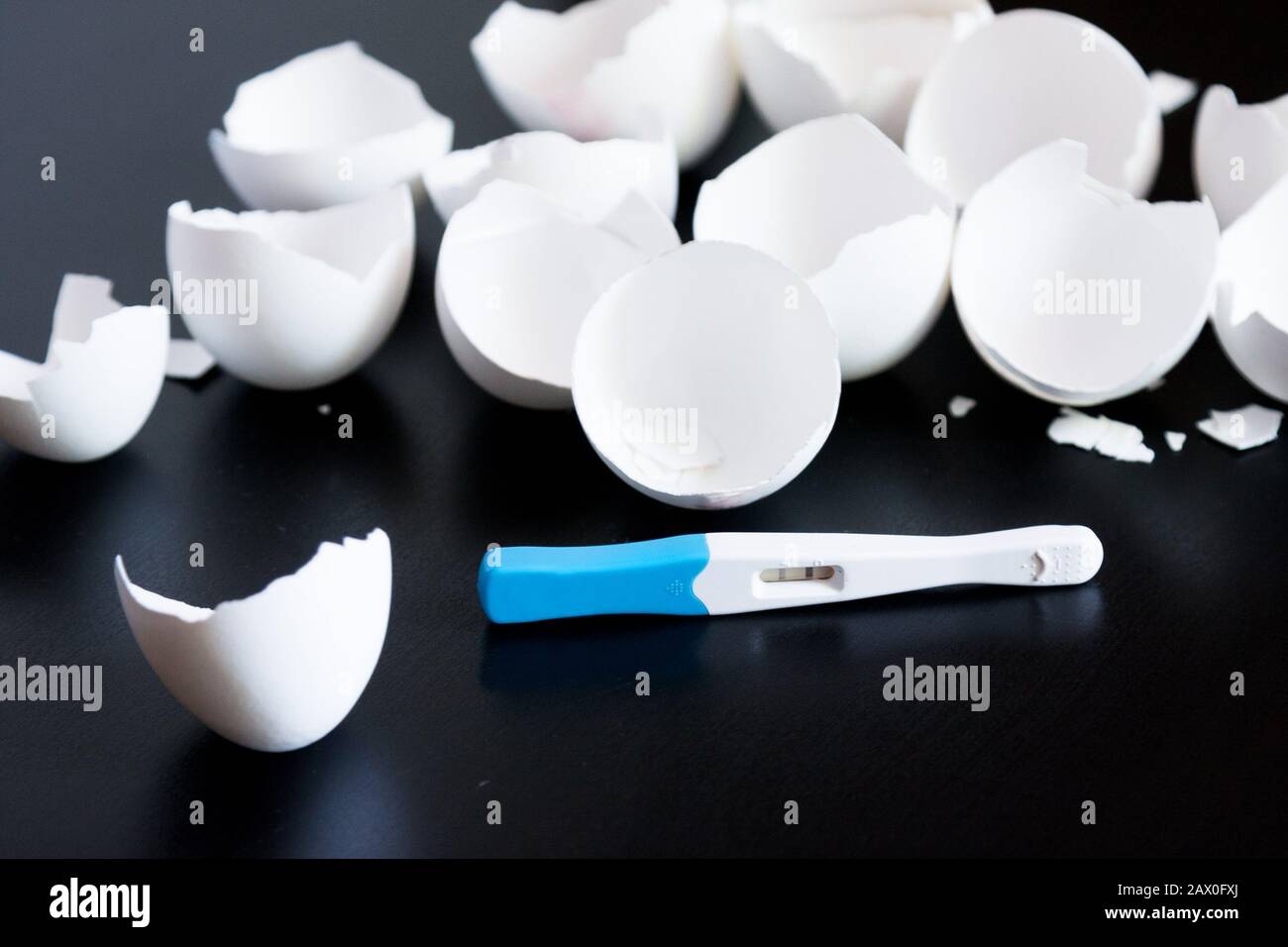 Infertility. Negative pregnancy test and eggshell on black Stock Photo ...