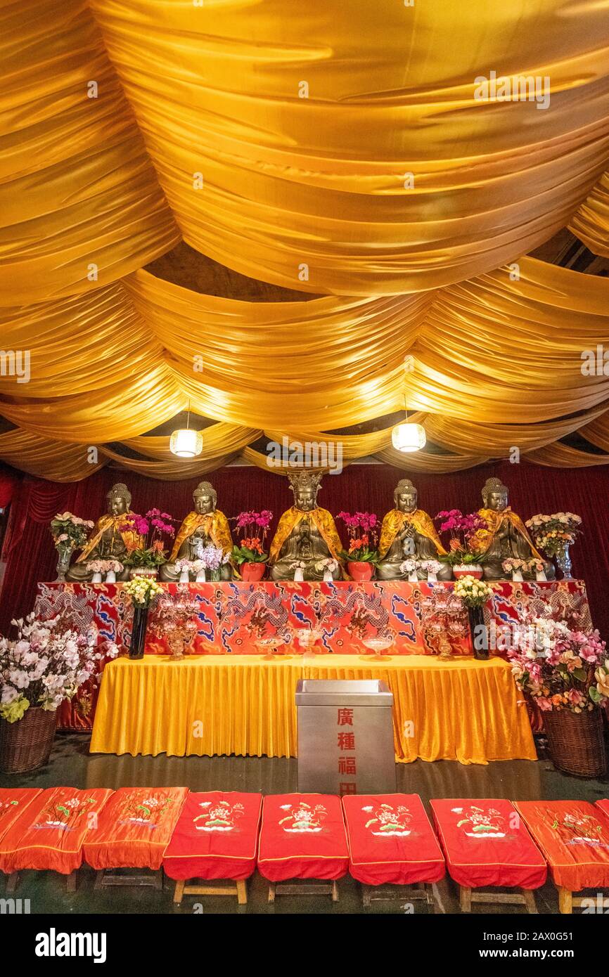 An altar in Jing'an Temple with multiple statues resting atop it ...