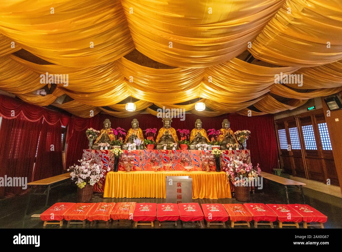 An altar in Jing'an Temple with multiple statues resting atop it ...