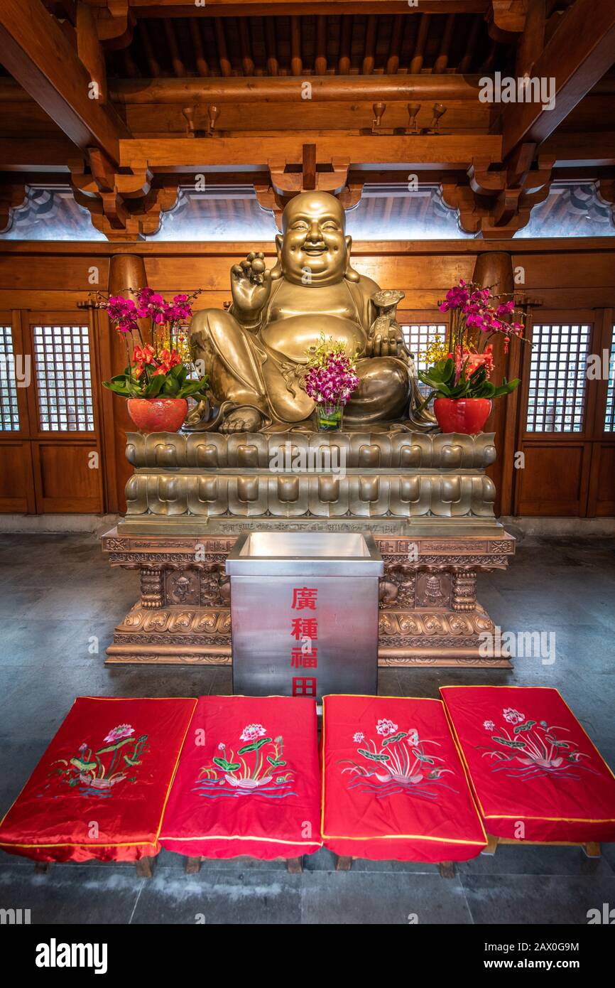 A statue in the Jing'an Temple surrounded by generous offerings ...