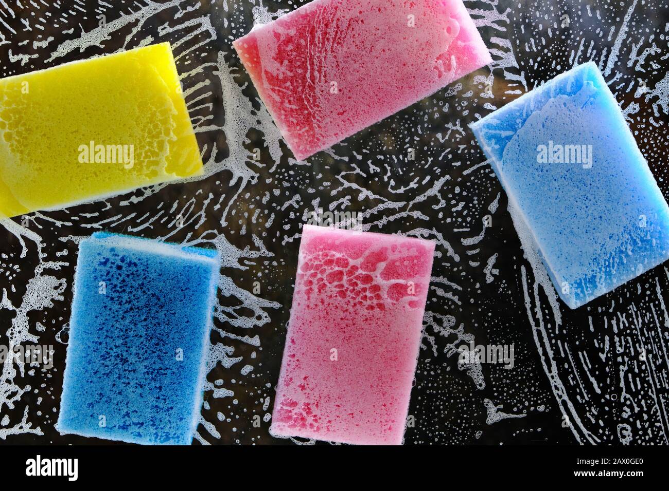 Multi-colored sponge for washing dishes on the glass with liquid and ...