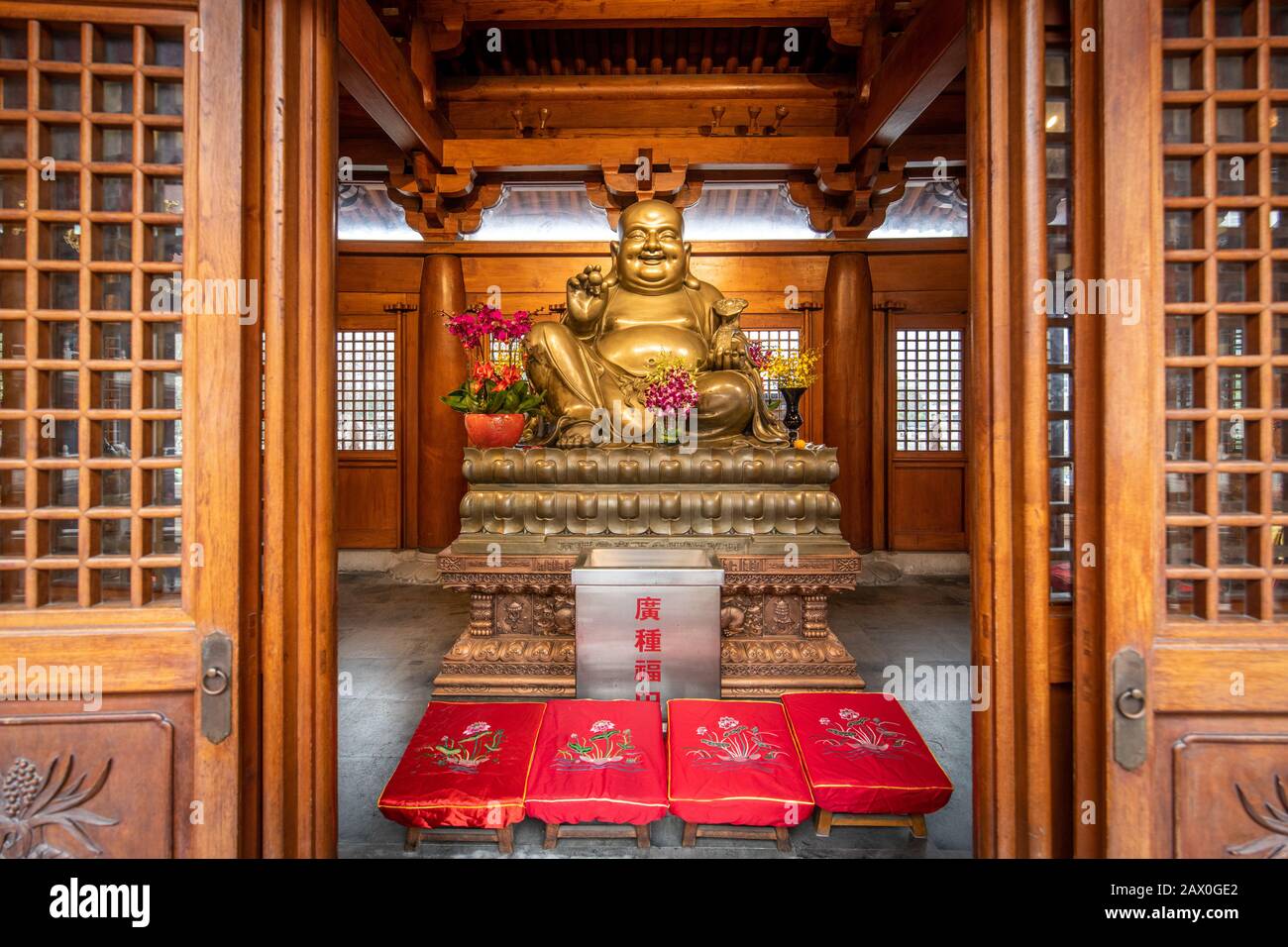A statue in the Jing'an Temple surrounded by generous offerings ...