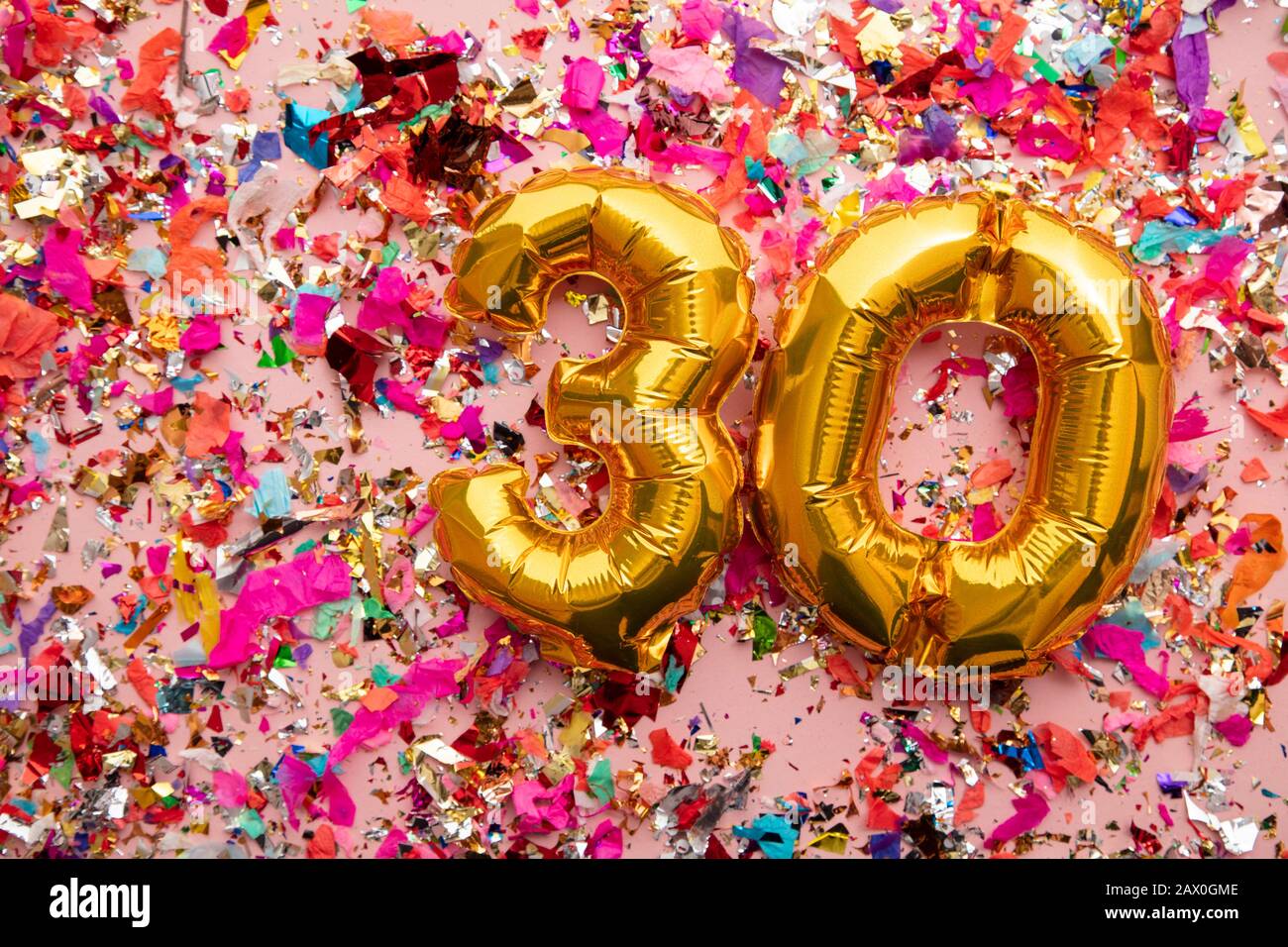 Number 30 gold birthday celebration balloon on a confetti glitter ...