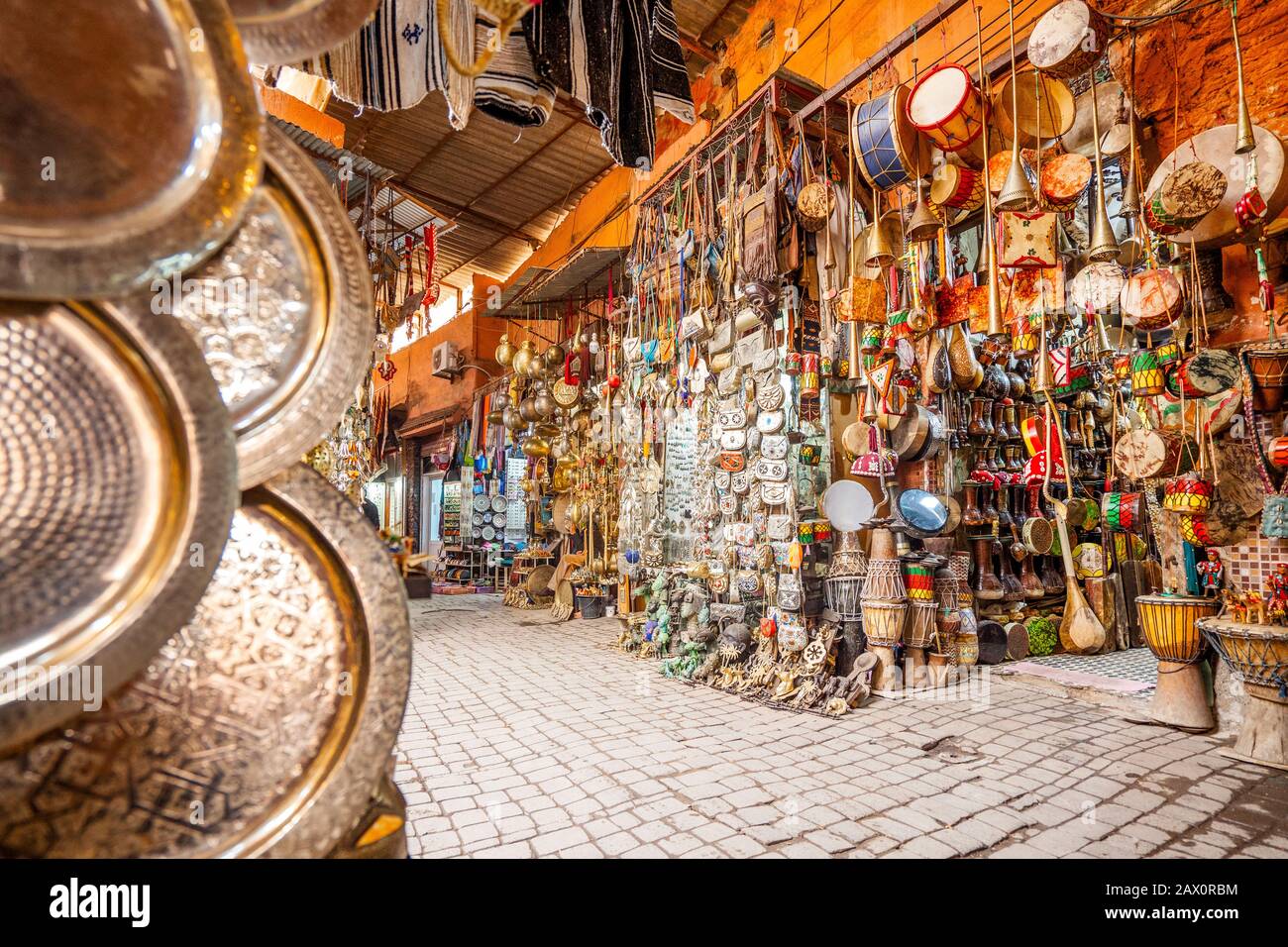 Narrow street in medina of Marrakech full of shops with metal and ...