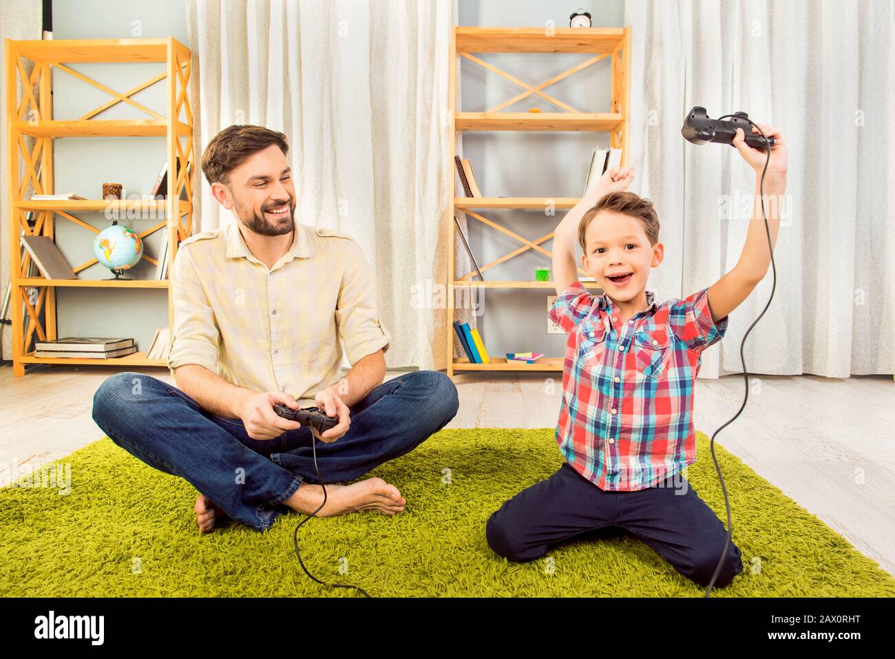 Father and son playing video games. Son winning Stock Photo - Alamy
