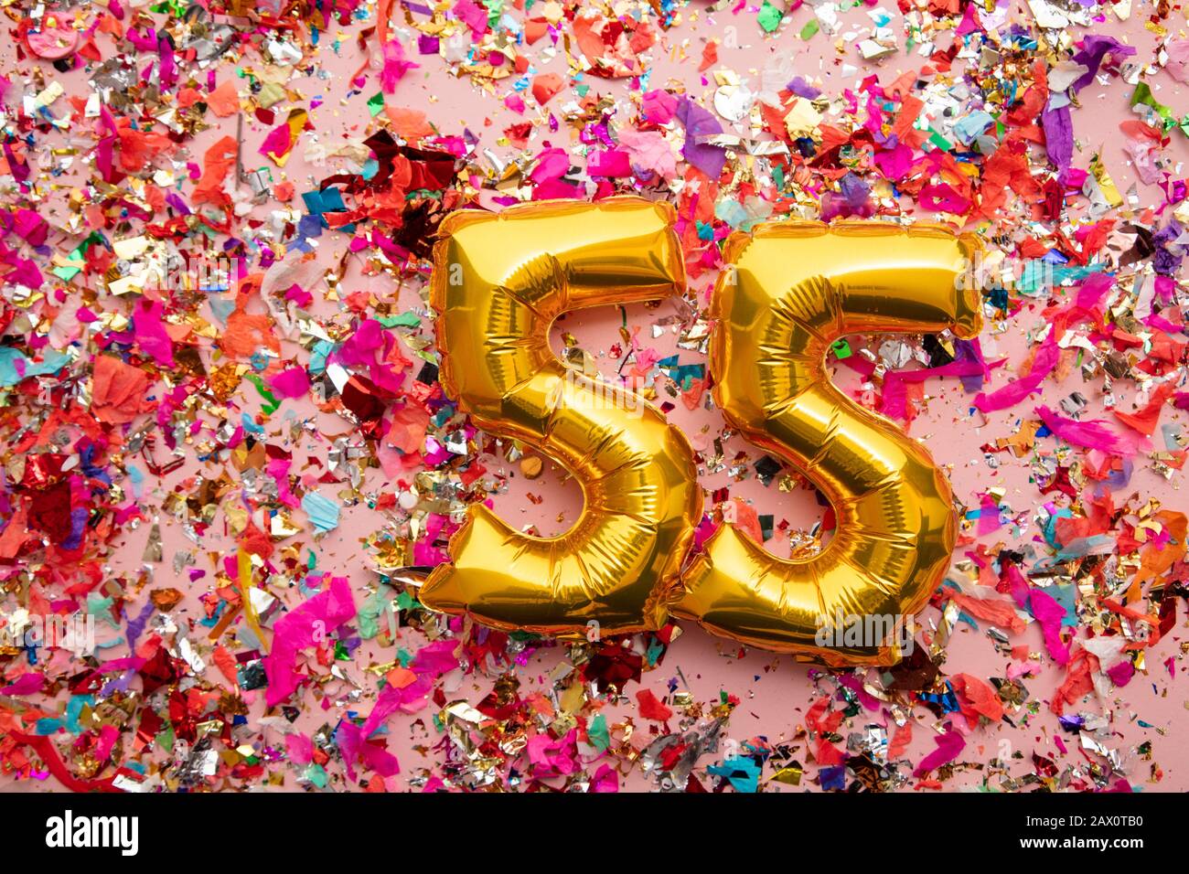 Number 55 gold birthday celebration balloon on a confetti glitter ...