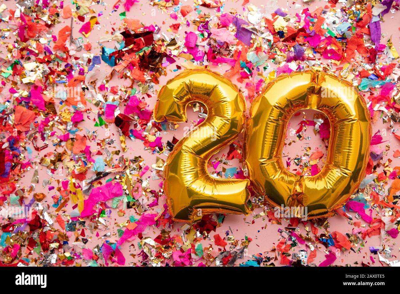 Number 20 gold birthday celebration balloon on a confetti glitter ...