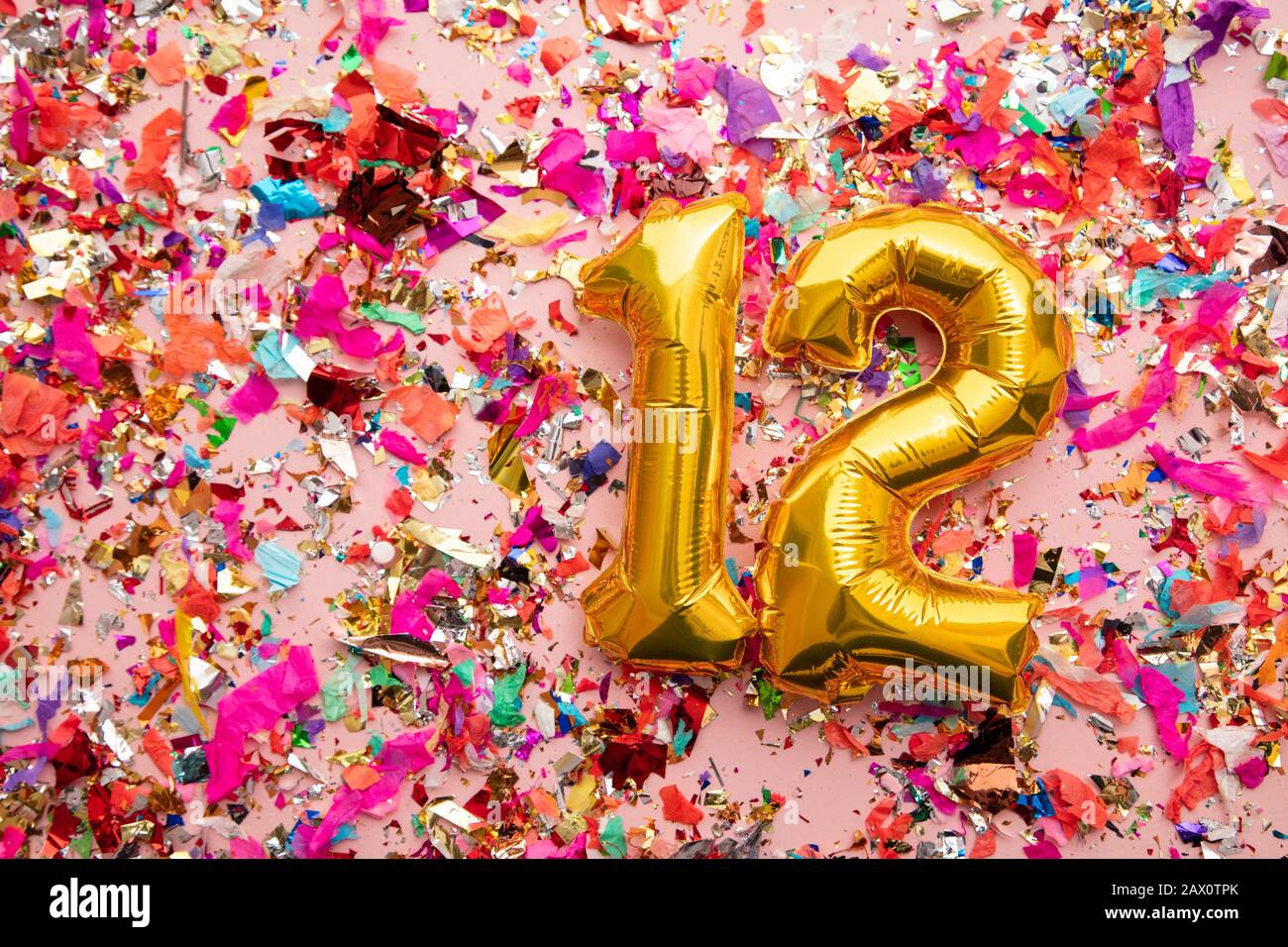 Number 12 gold birthday celebration balloon on a confetti glitter ...