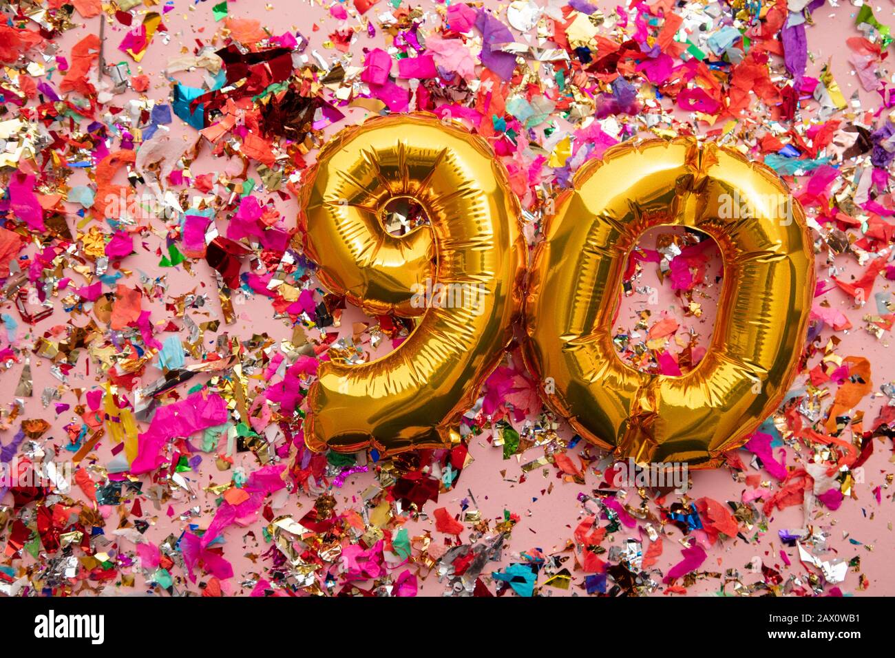 Number 90 gold birthday celebration balloon on a confetti glitter ...