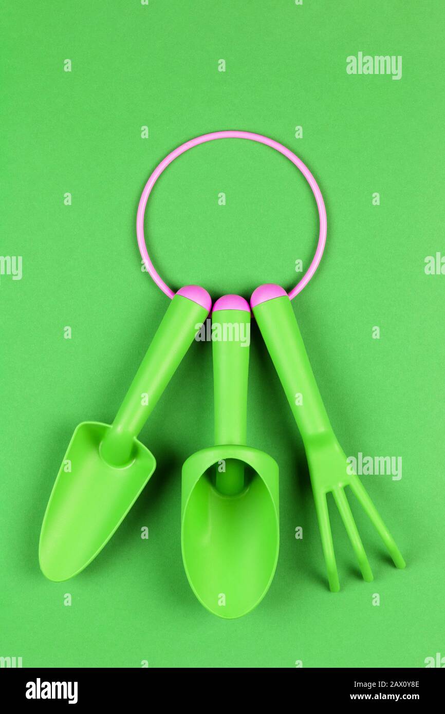 set of green plastic garden tools on a green background close up top ...