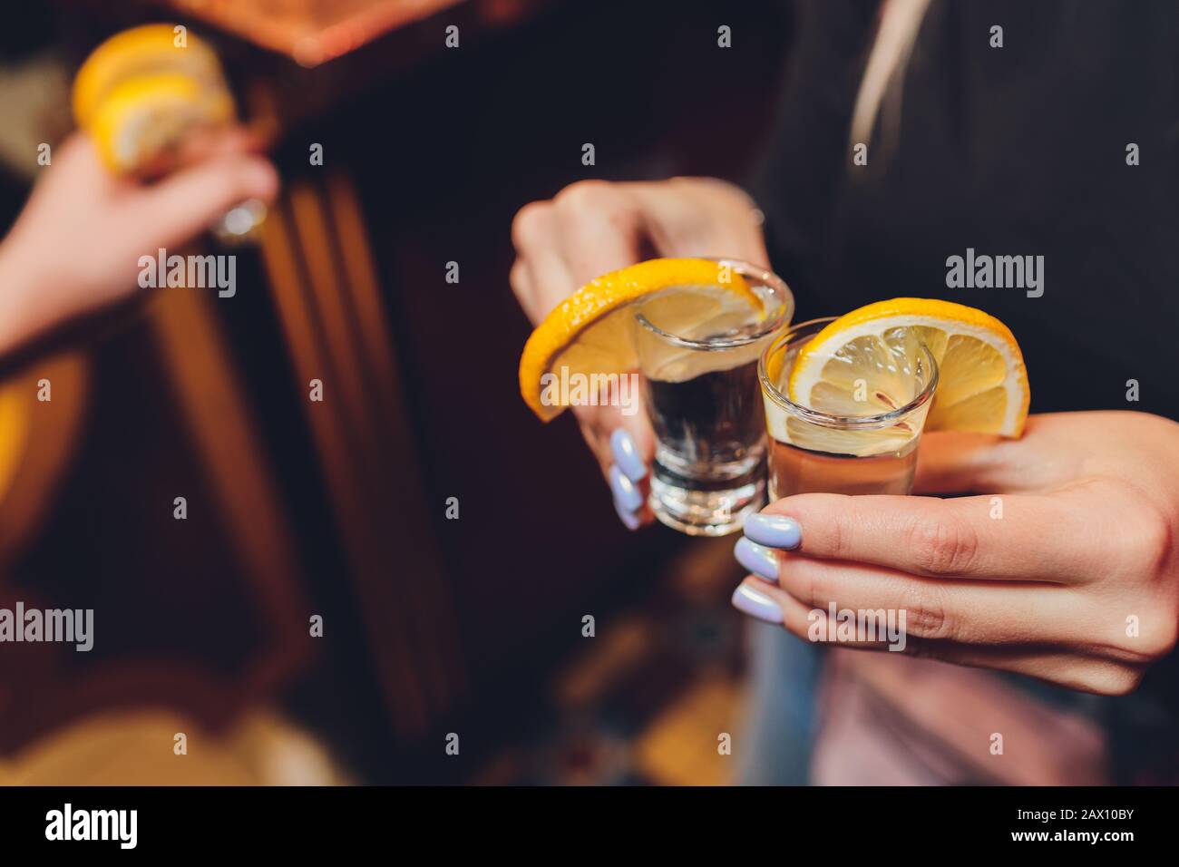 Friends toasting with shot glasses above an old wooden table black ...