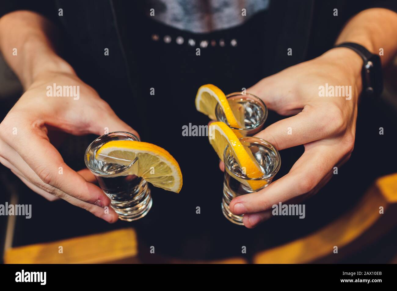Friends toasting with shot glasses above an old wooden table black ...
