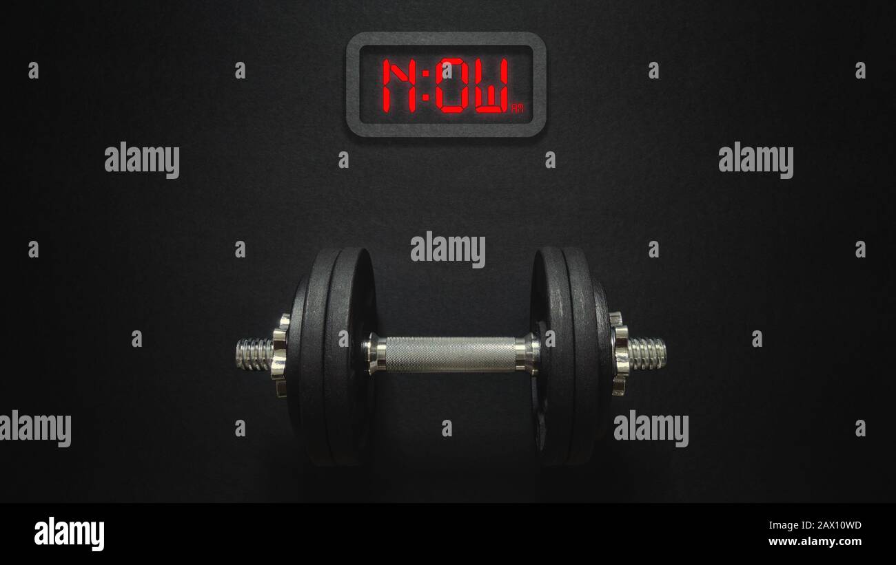 Flat lay of dumbbell with digital clock now it's the time for workout ...