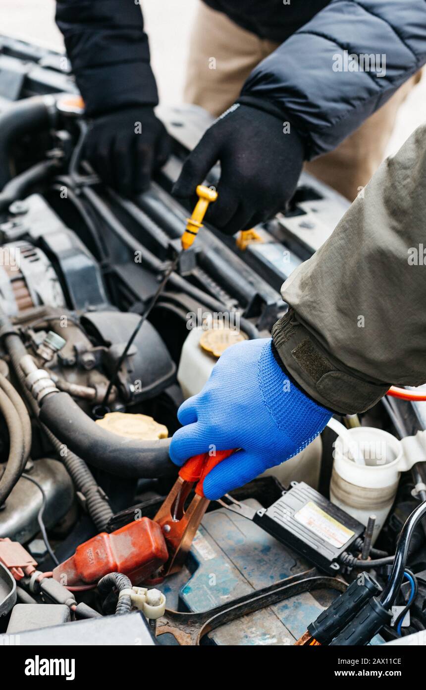Two Car mechanic engineers checking, fixing the car, making maintenance ...