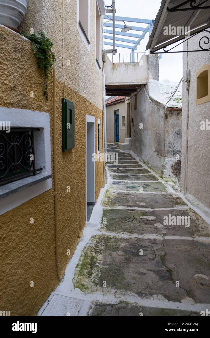 Traditional greek whitewashed buildings and narrow cobblestone streets ...