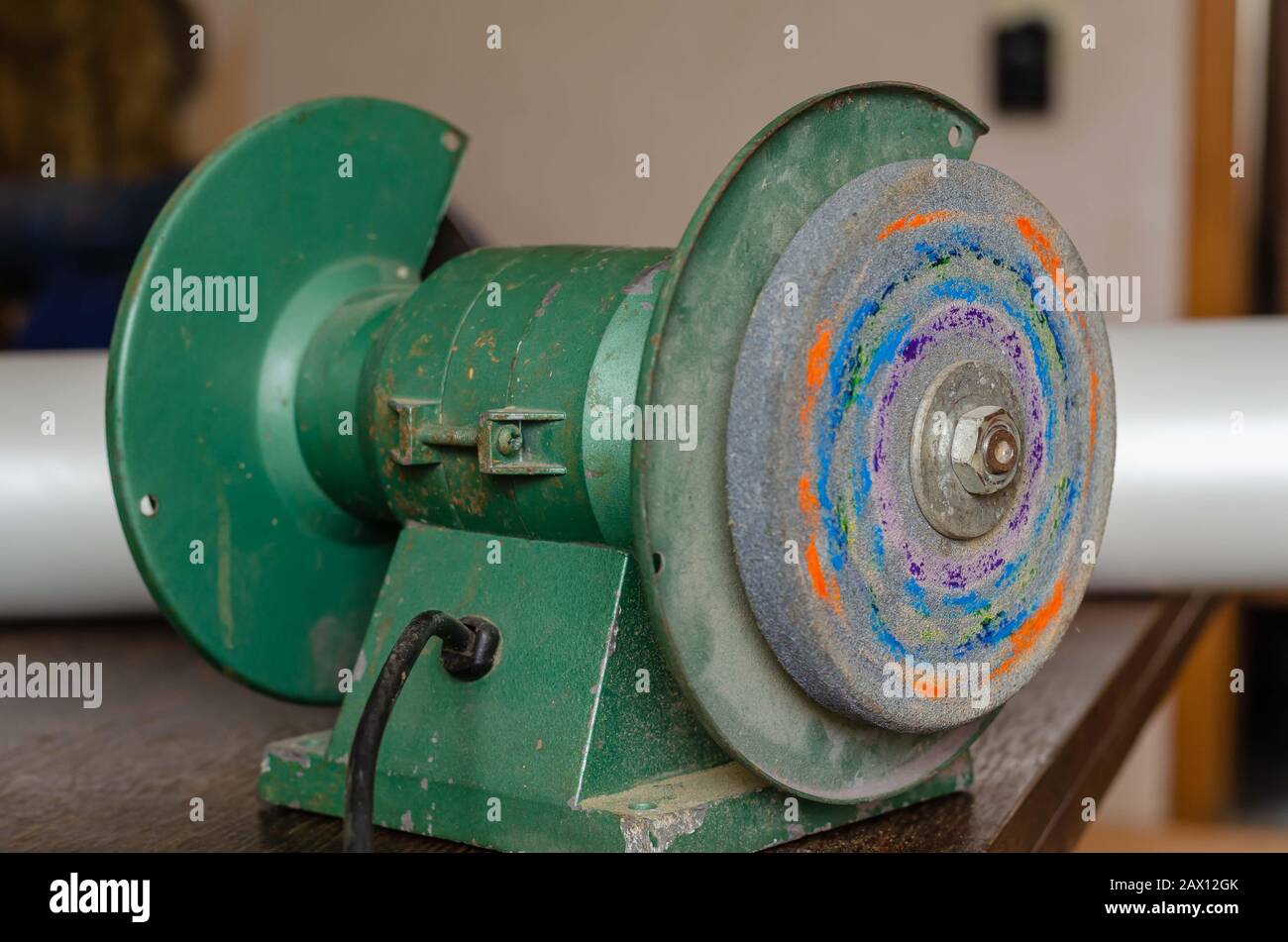 Used electric emery with traces of paint on the emery wheel. Side view ...