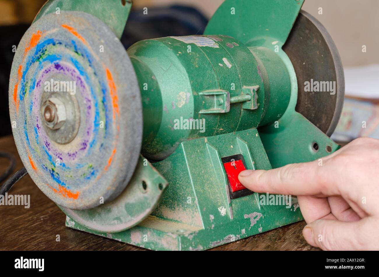 Used electric emery with traces of paint on the emery wheel. Side view ...