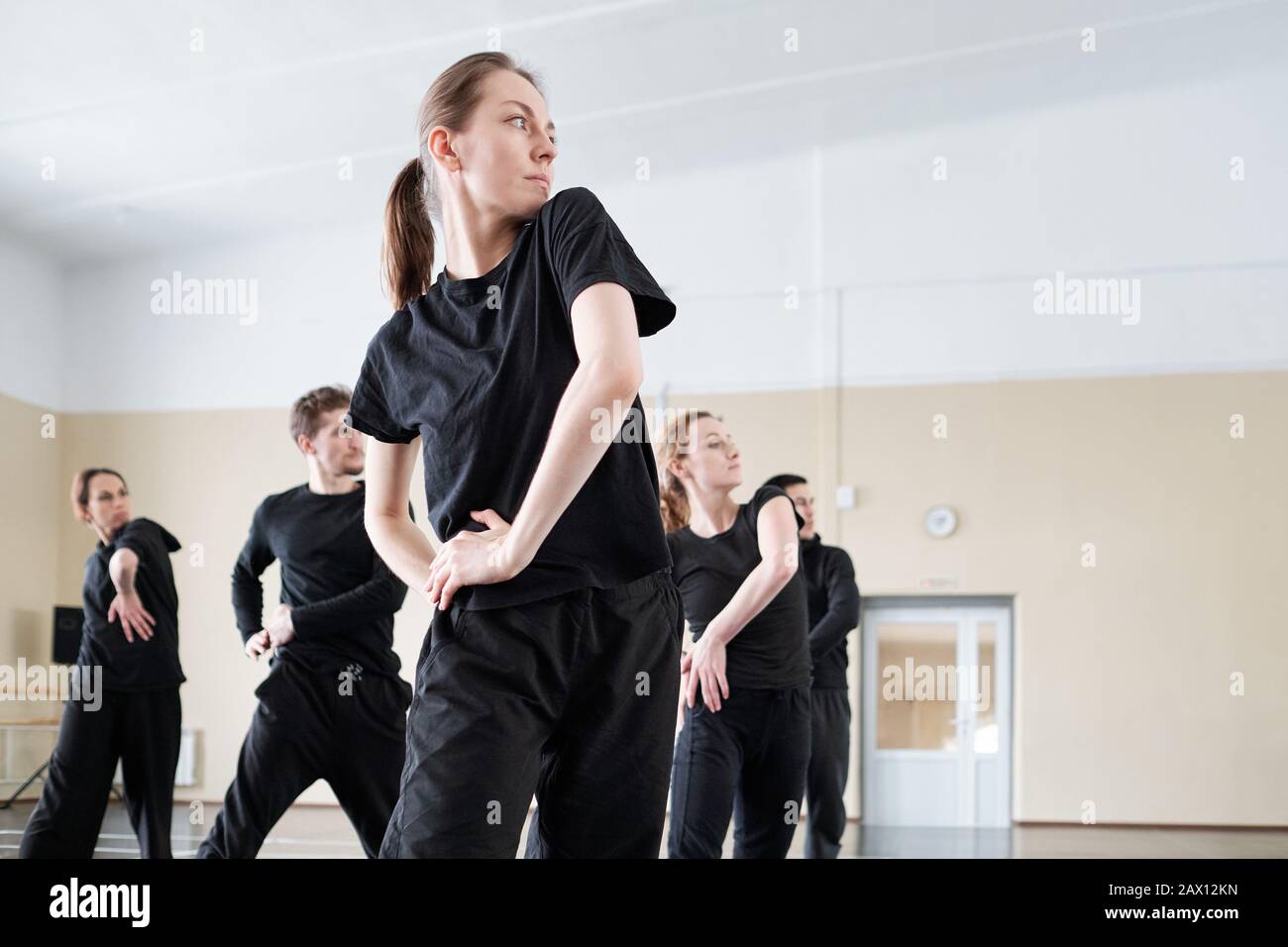 Group of young people in black outfits dancing together in rehearsal ...