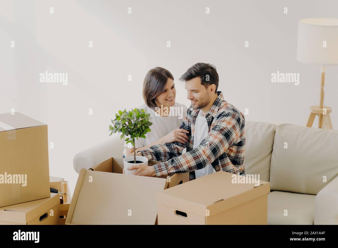 Happy couple in love settle in new home, unpack boxes with household ...