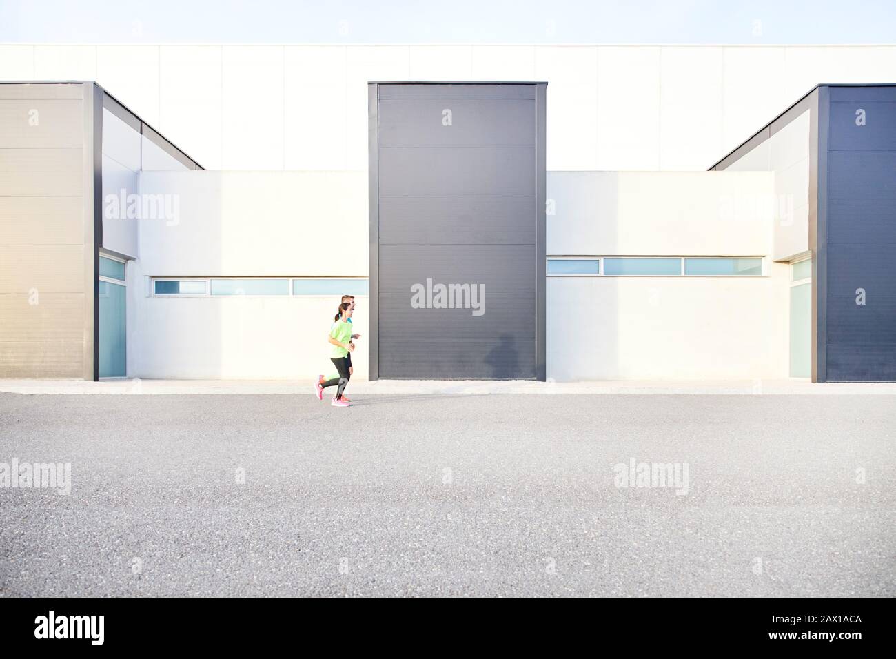 couple of runners running with a modern building in the background ...
