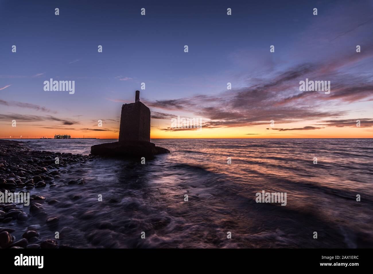 Pylon in the sea in a beautiful sunrise Stock Photo - Alamy