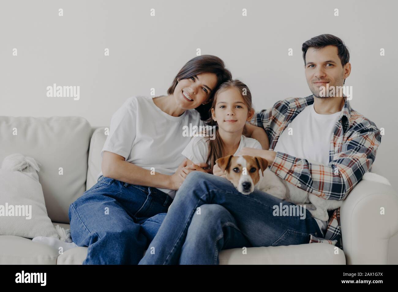 Portrait of affectionate family cuddle and sit together at couch in ...